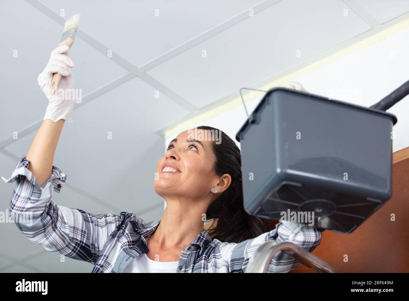 beautiful female worker painting ceiling Stock Photo - Alamy