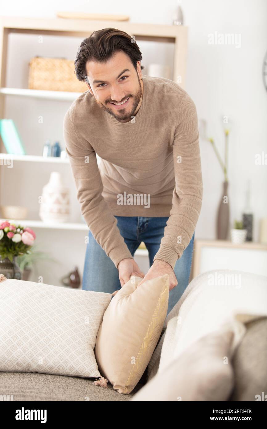 nice man standing in the living room cleaning the house Stock Photo - Alamy