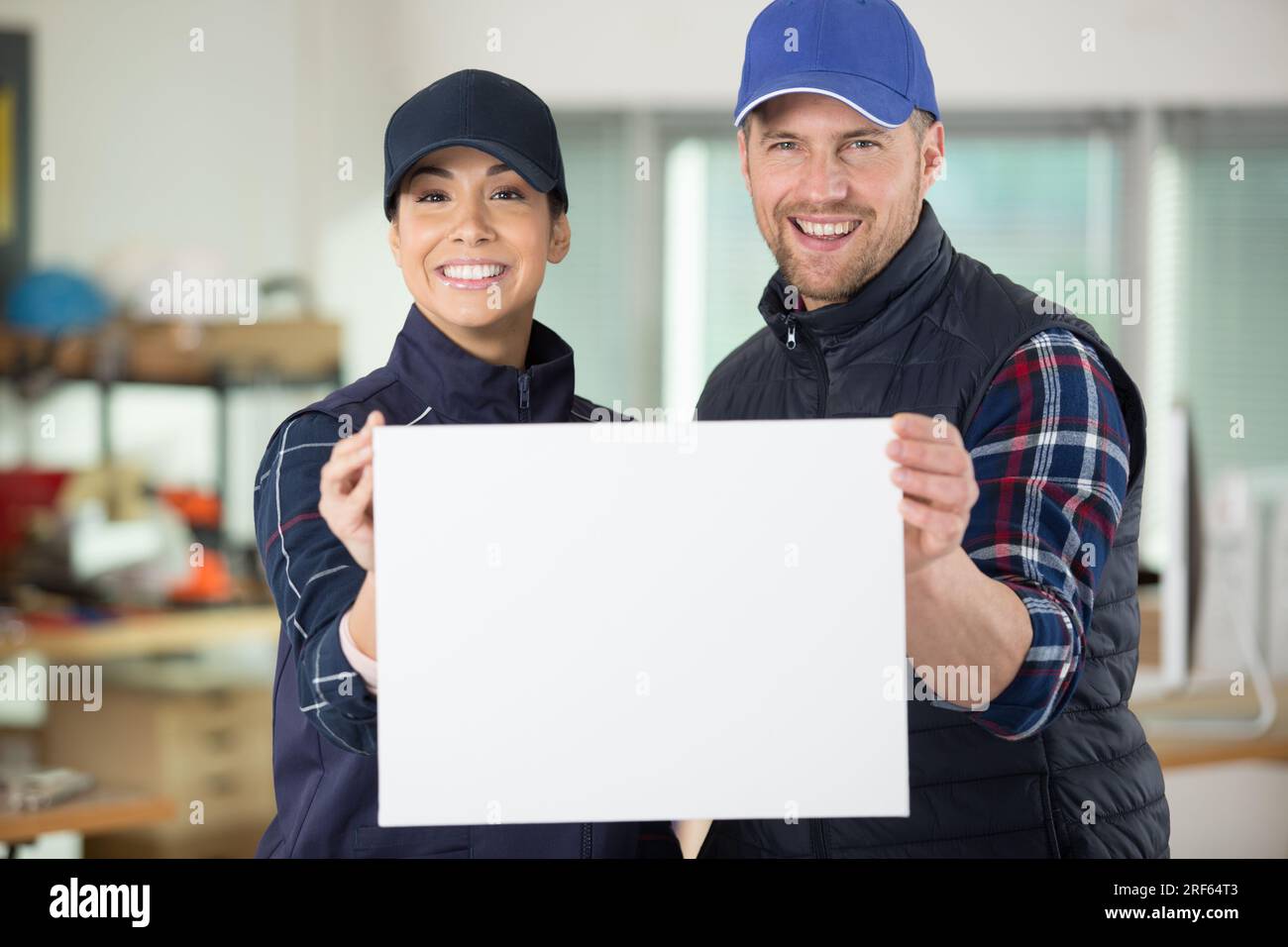two engineers holding white board Stock Photo - Alamy