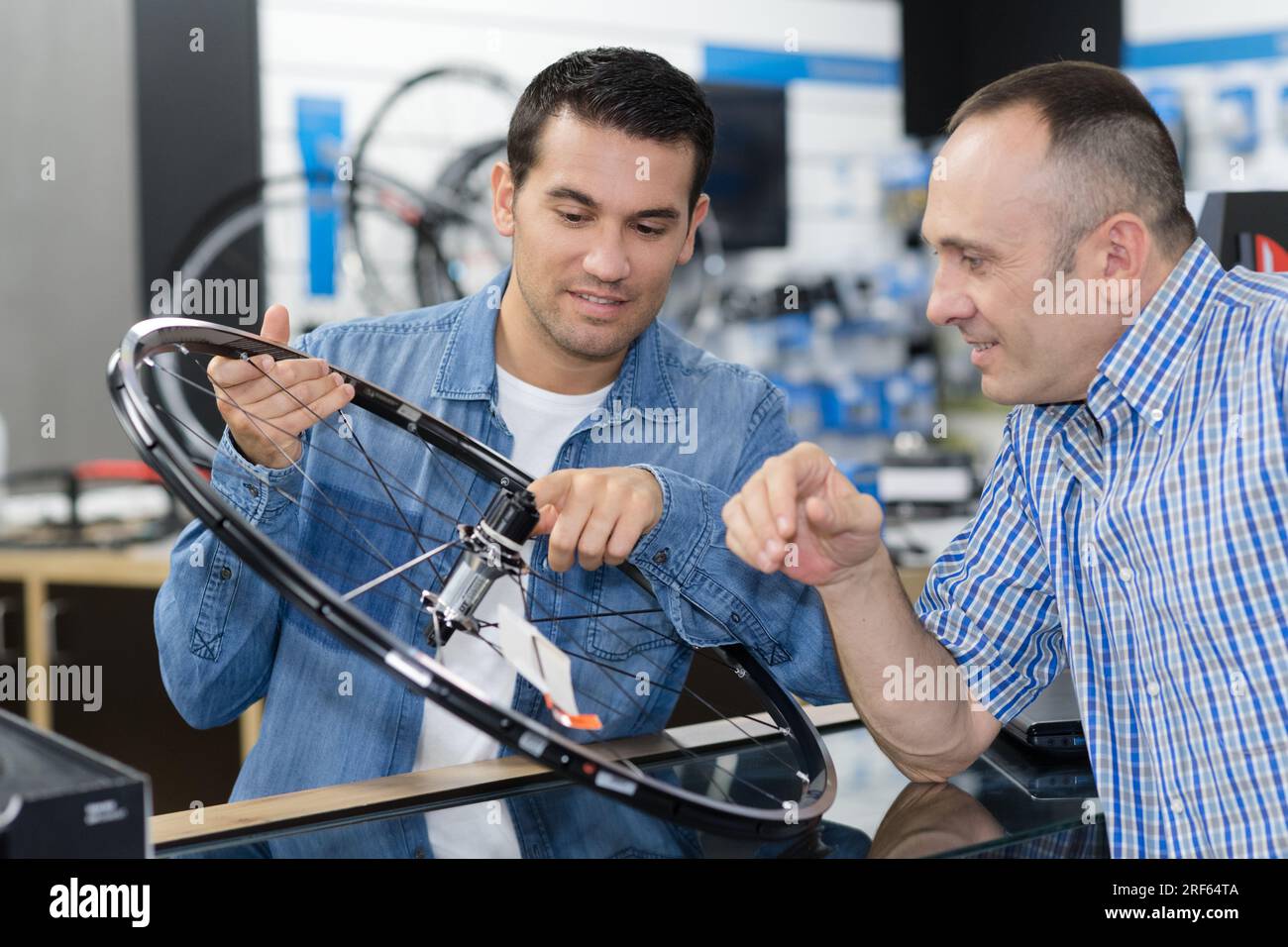 customer showing bicycle mechanic a problem on bike Stock Photo - Alamy
