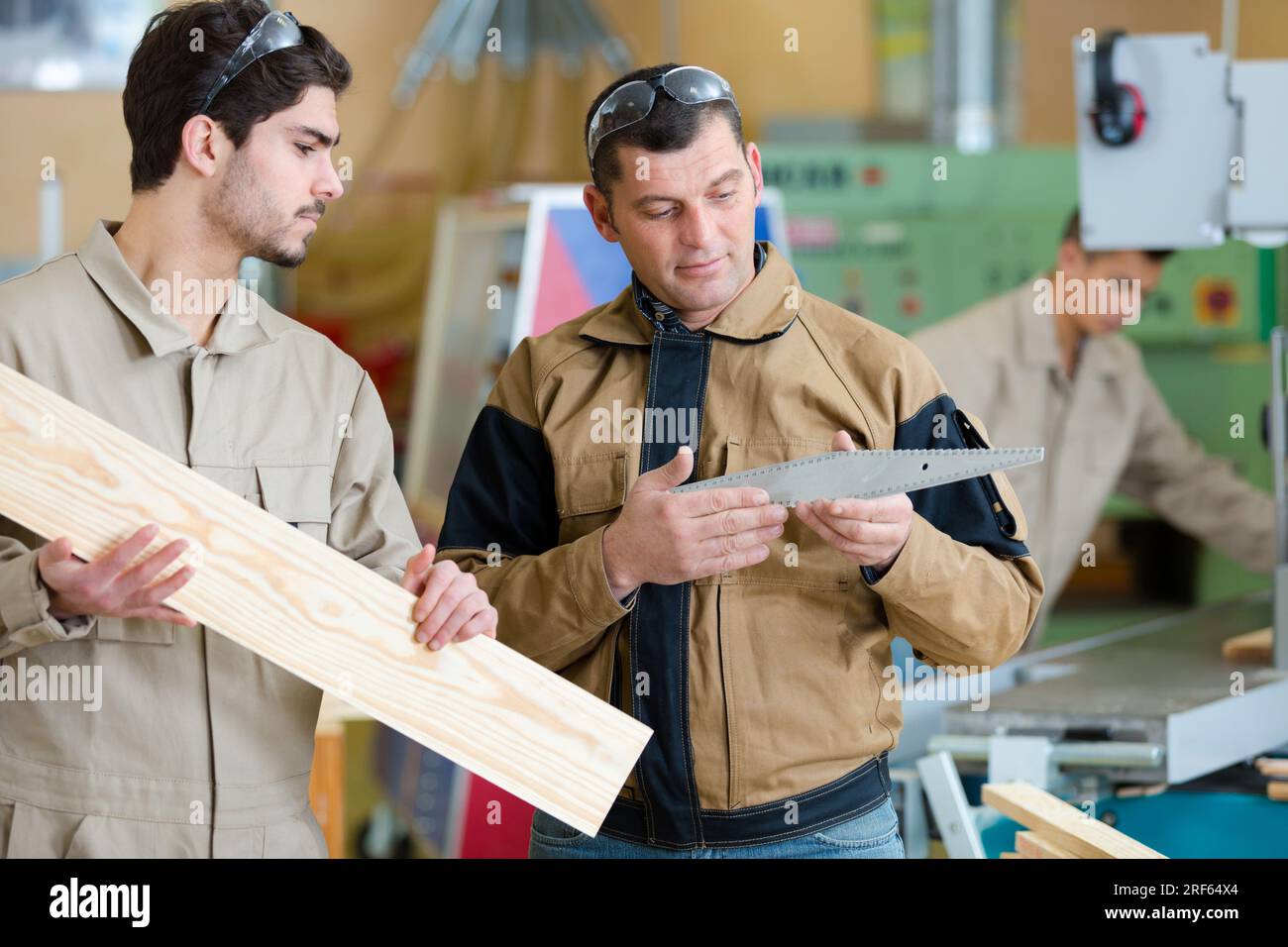 tutor training apprentice carpenter to use woodworking implement Stock ...