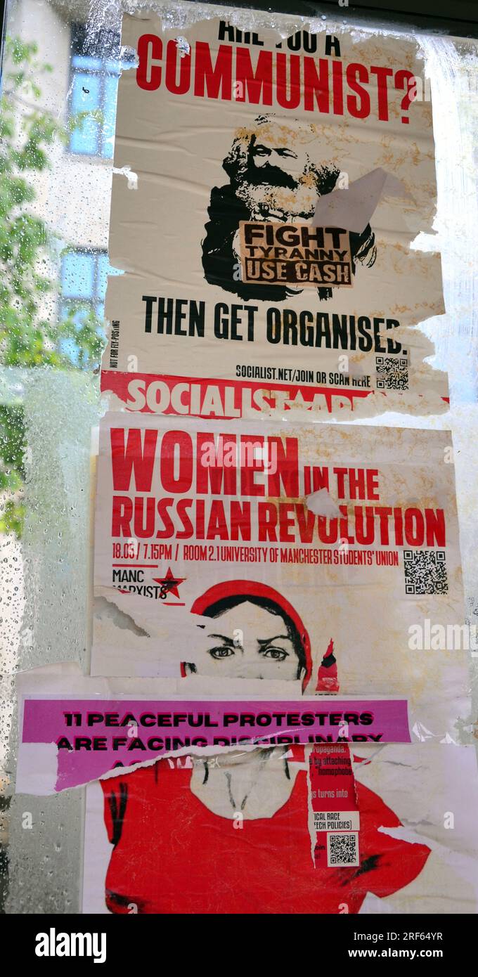 ripped or torn posters and graffiti on them at the University of Manchester, bus stop next to ...