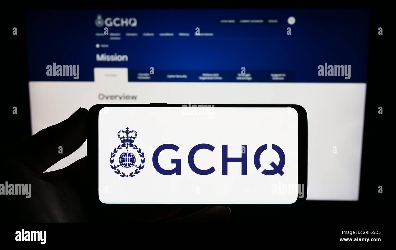 Person holding mobile phone with logo of Government Communications ...