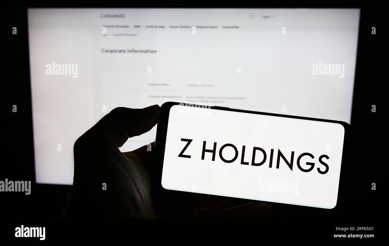 Person holding mobile phone with logo of Japanese company Z Holdings ...