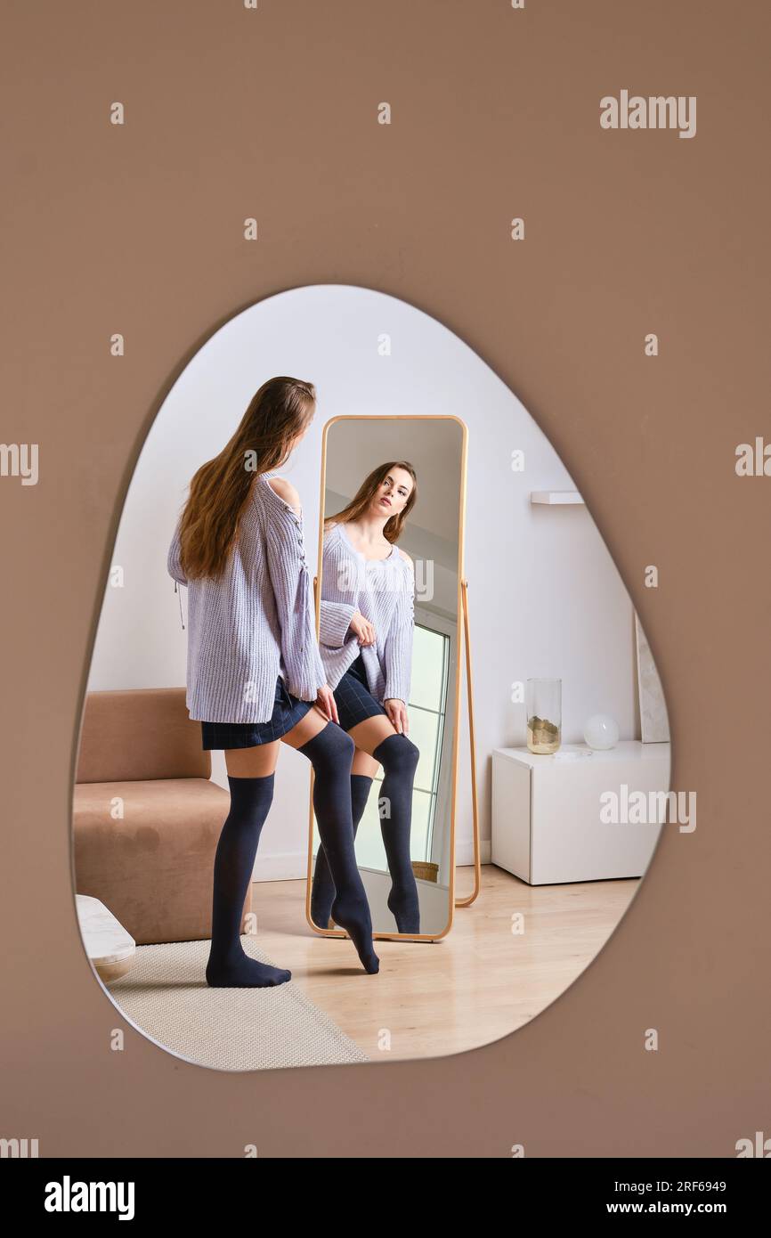 Reflection of woman dressing in front of mirror at home Stock Photo - Alamy