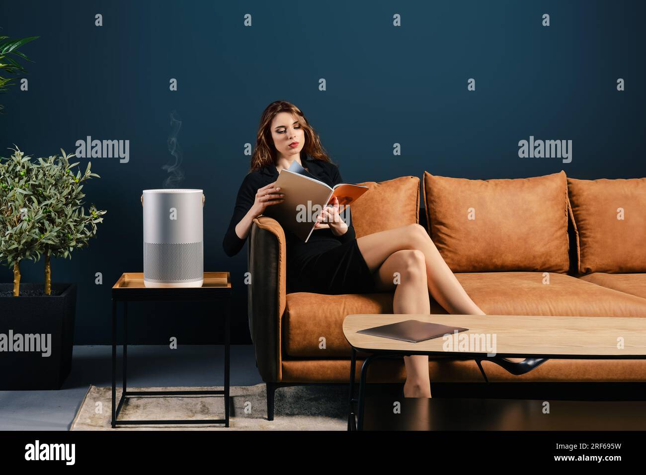 Confident young woman waiting for an appointment and reading magazine ...