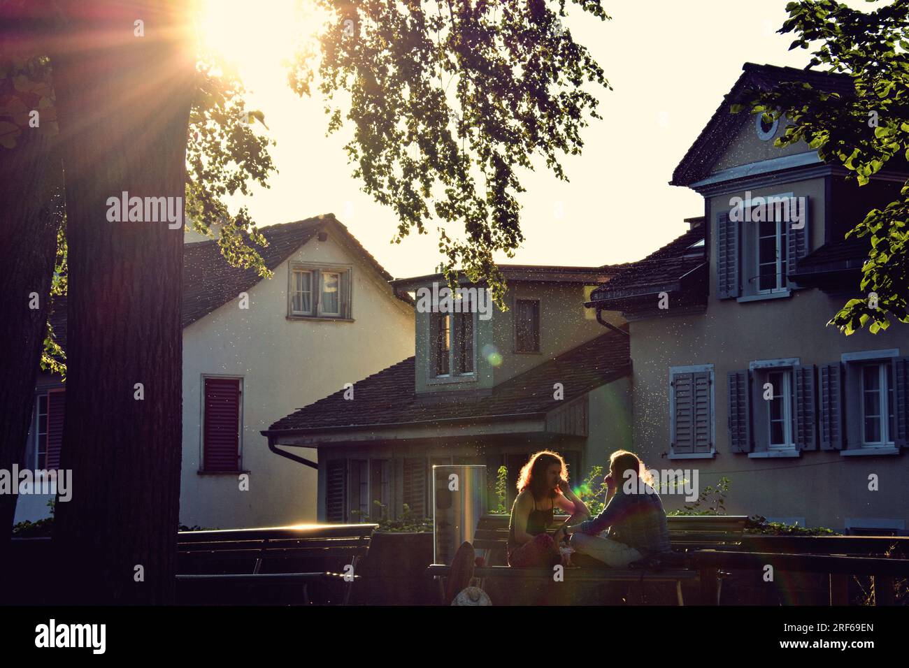 Leisure Time at Sunset - Two Friends Talking on a Park Bench Stock ...