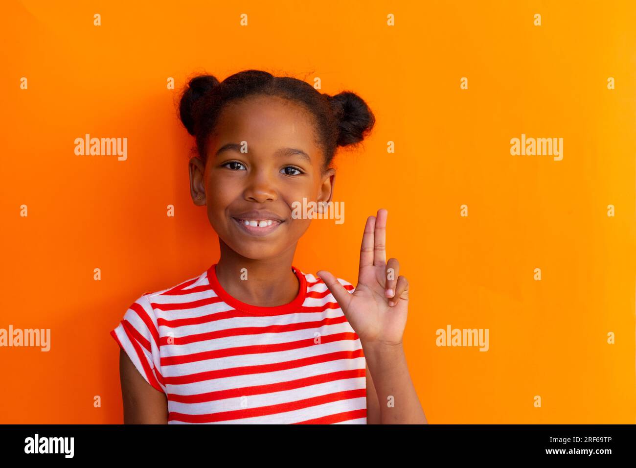 Happy african american schoolgirl doing oing sign language with hand ...