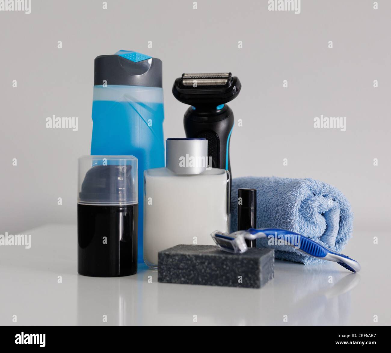 Bottles of cosmetic products and razors for men on light background ...