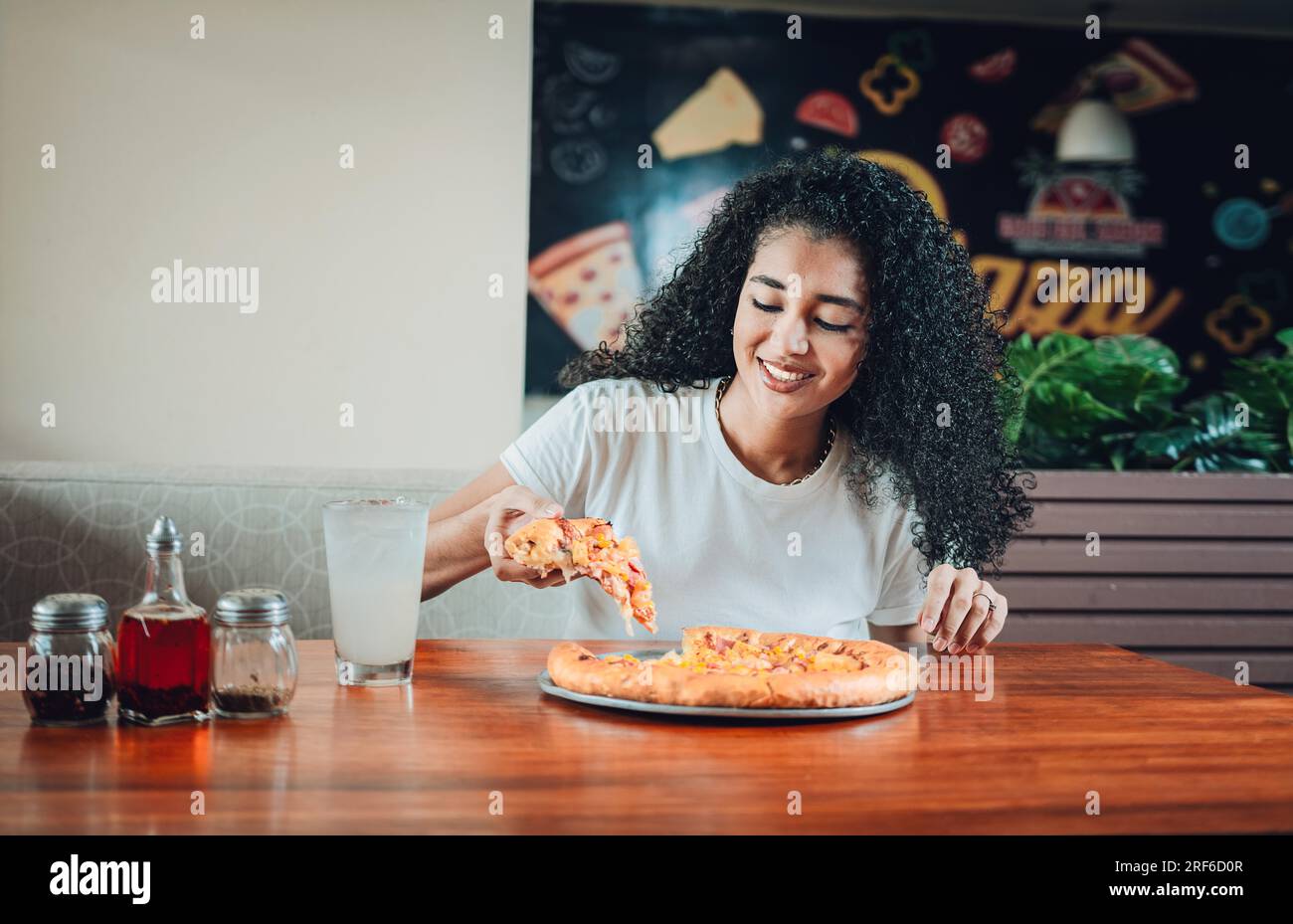 Hispanic girl eating pizza hi-res stock photography and images - Alamy