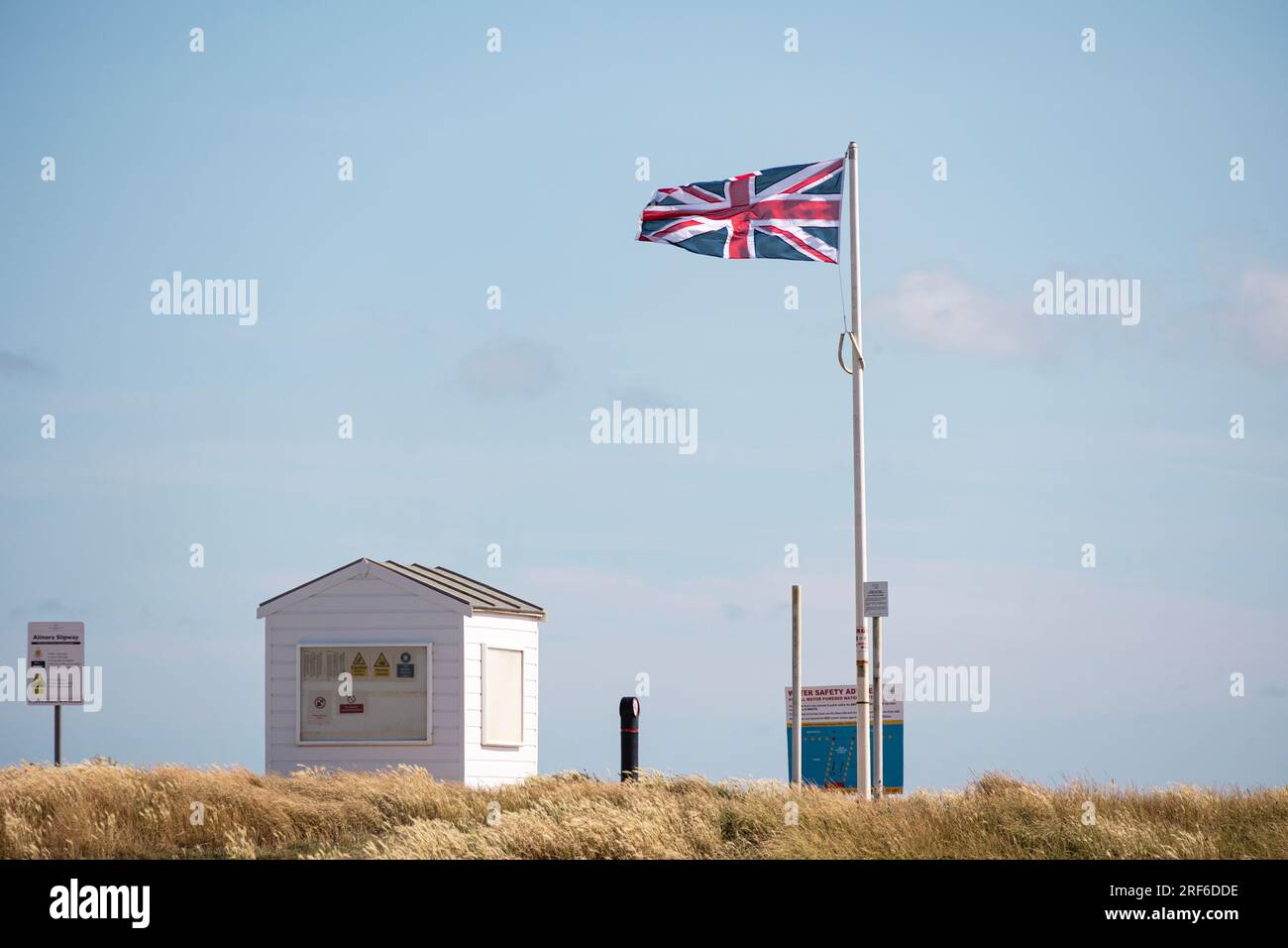 a beach hut and union flag on Worthing Beach on a windy day in summer ...