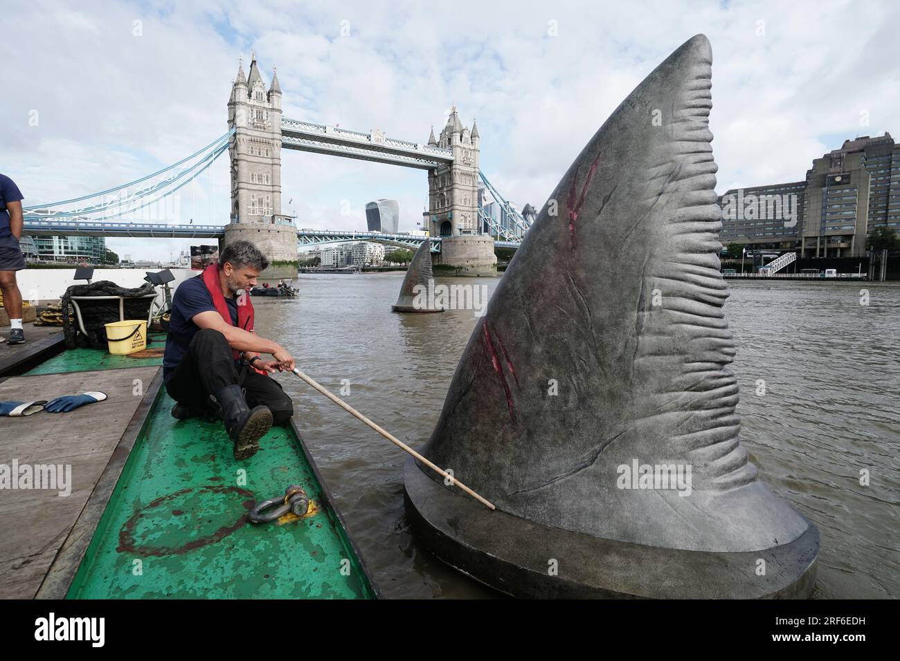 Floating models of megalodon shark fins by Tower Bridge during a ...