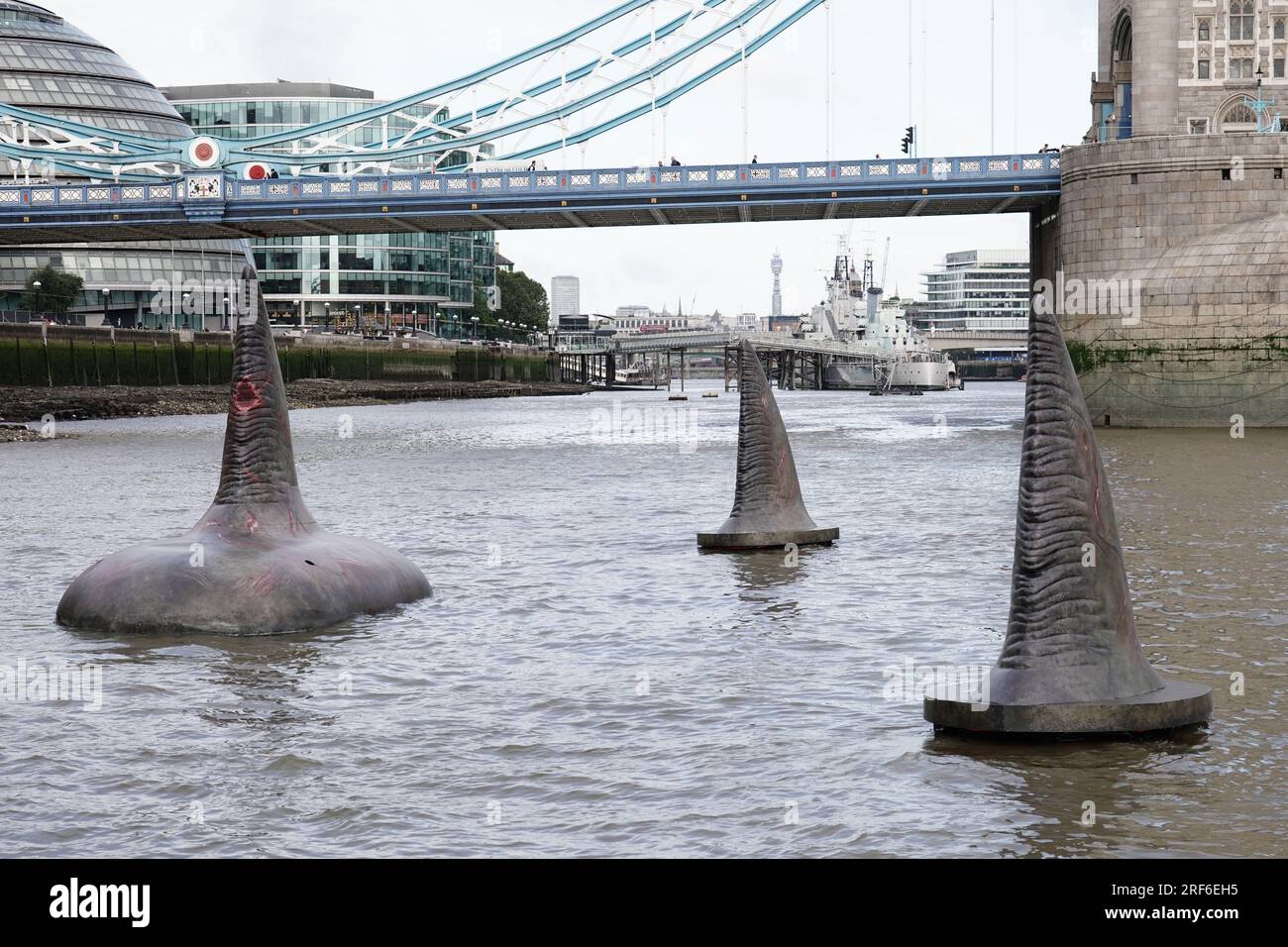 Floating models of megalodon shark fins by Tower Bridge during a ...