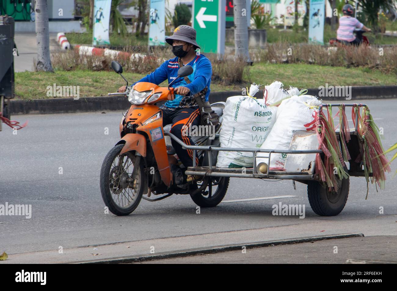 RATCHABURI, THAILAND, OCT 18 2022, A man drives a motorcycle with an ...