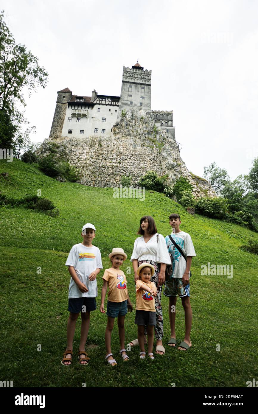 Family tourists against Bran Castle in Romania. Dracula medieval castle ...