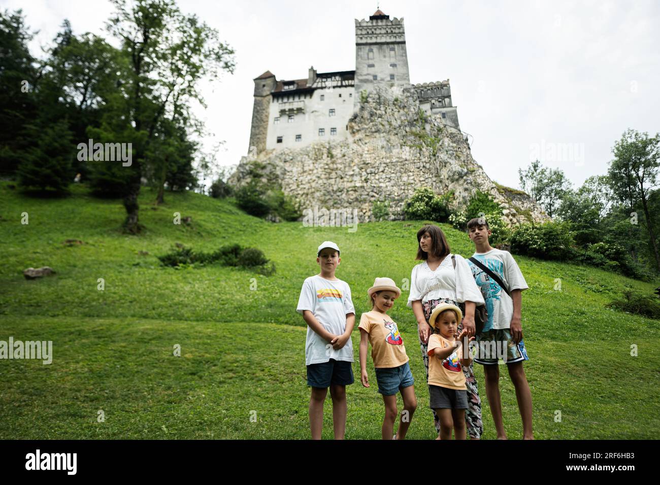 Family tourists against Bran Castle in Romania. Dracula medieval castle ...