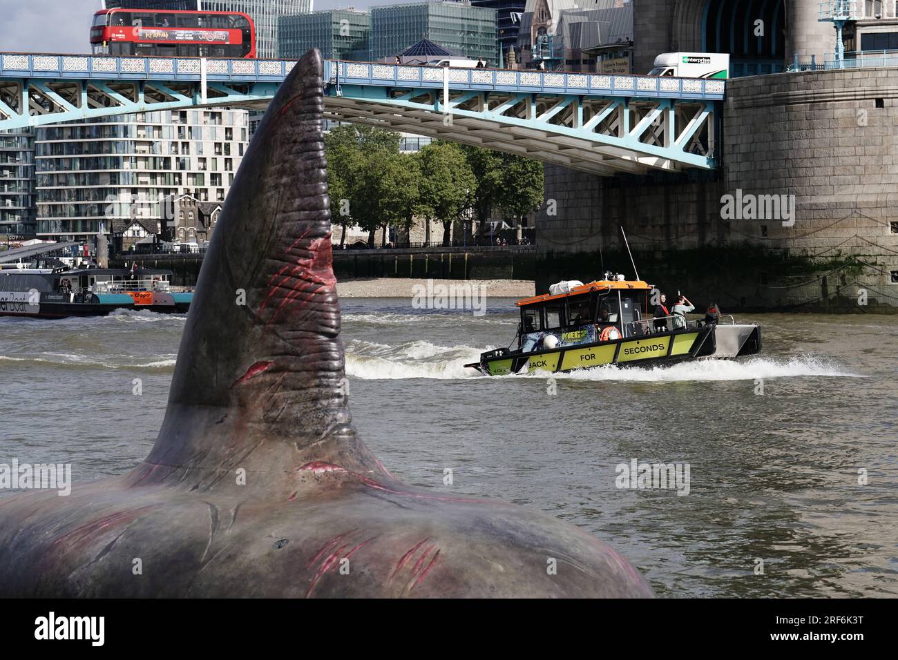 Floating models of megalodon shark fins by Tower Bridge during a ...