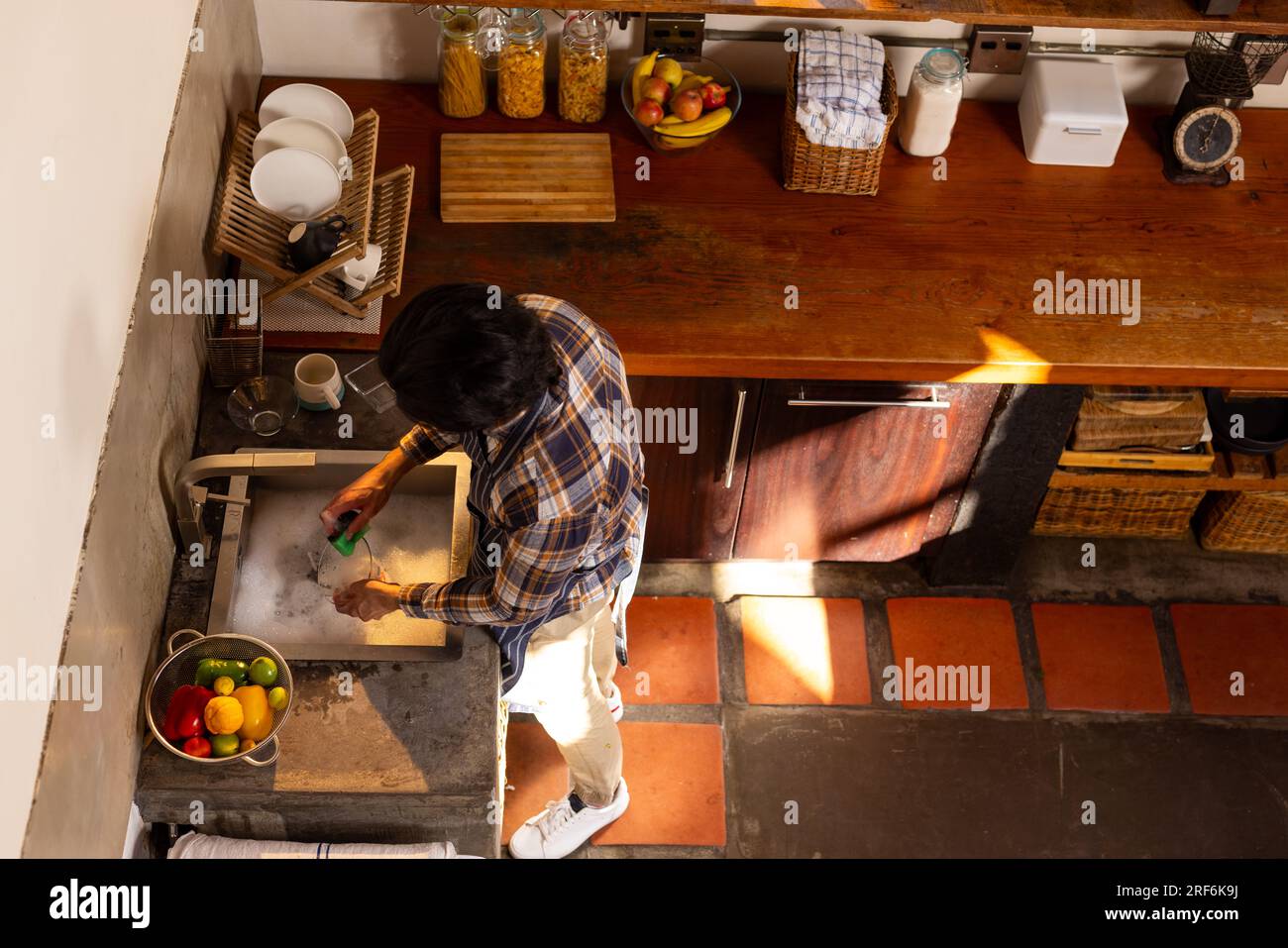 Indian man washing dishes in sunny kitchen at home, copy space Stock ...