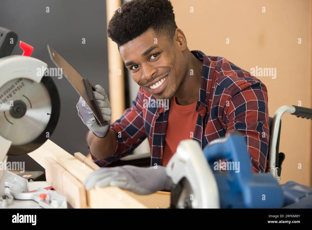 young carpenter using saw inside warehouse Stock Photo - Alamy