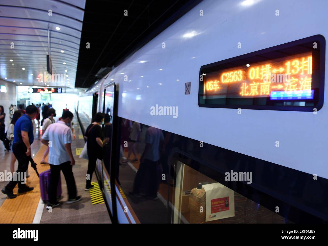 (230801) -- BEIJING, Aug. 1, 2023 (Xinhua) -- Passengers board a train operating on the Beijing ...