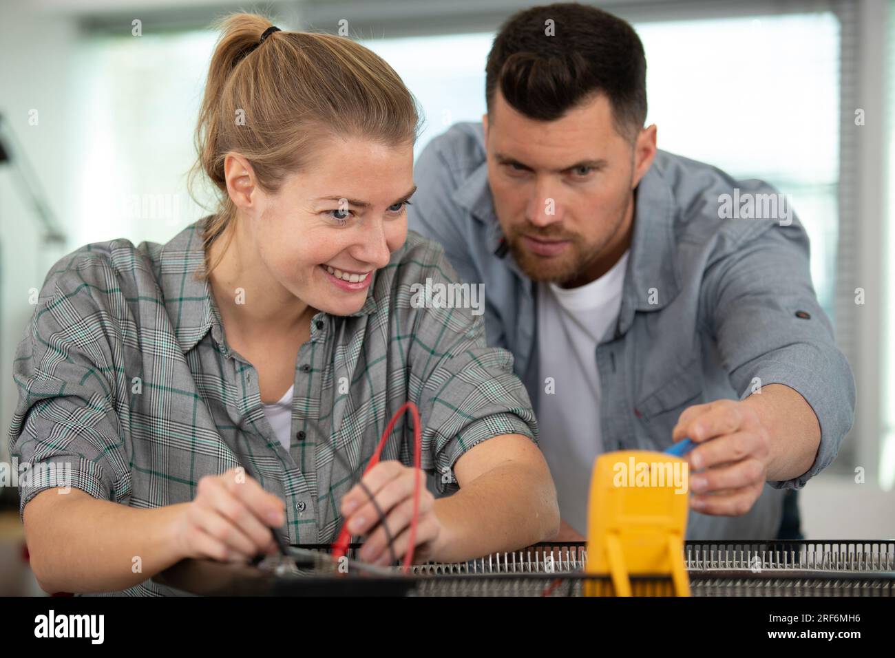 happy young female woker measuring electrical current Stock Photo - Alamy