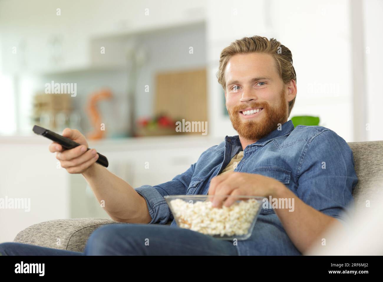 happy man with tv remote control and popcorn Stock Photo - Alamy