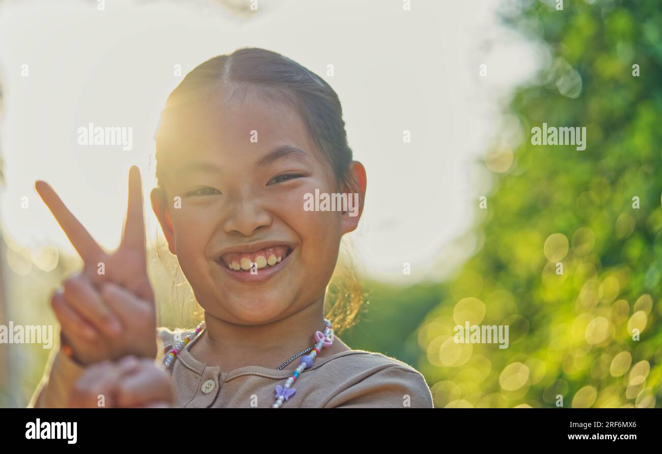 Happy Asian child girl with sunset light, light flare from behind ...