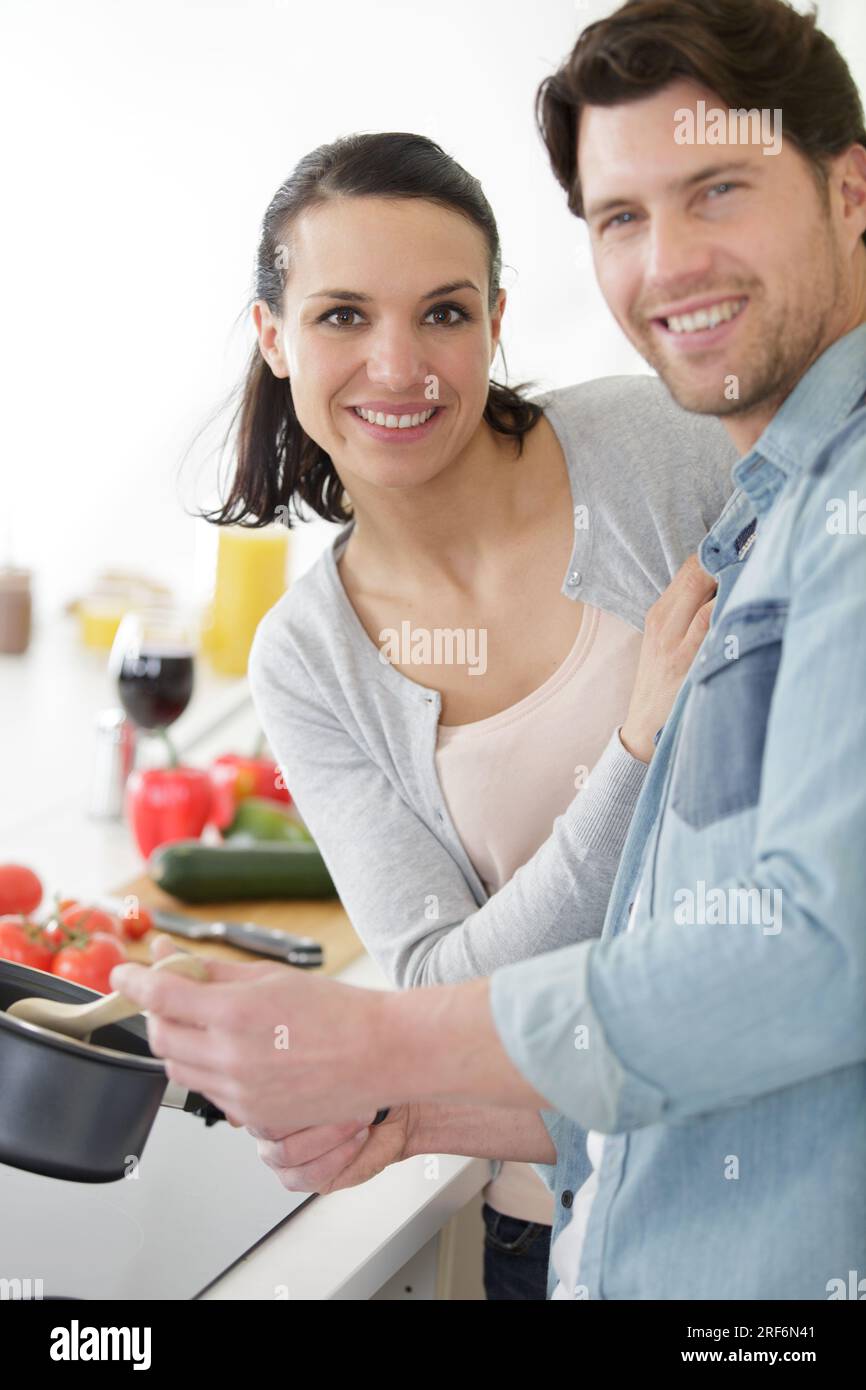 a couple hugging while cooking Stock Photo - Alamy
