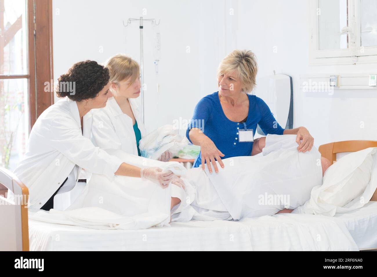 nurses practicing how to roll a patient with dummy Stock Photo - Alamy