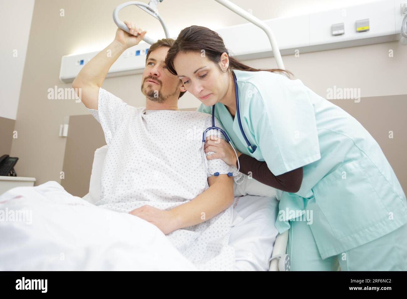 helping male patient out of bed Stock Photo - Alamy