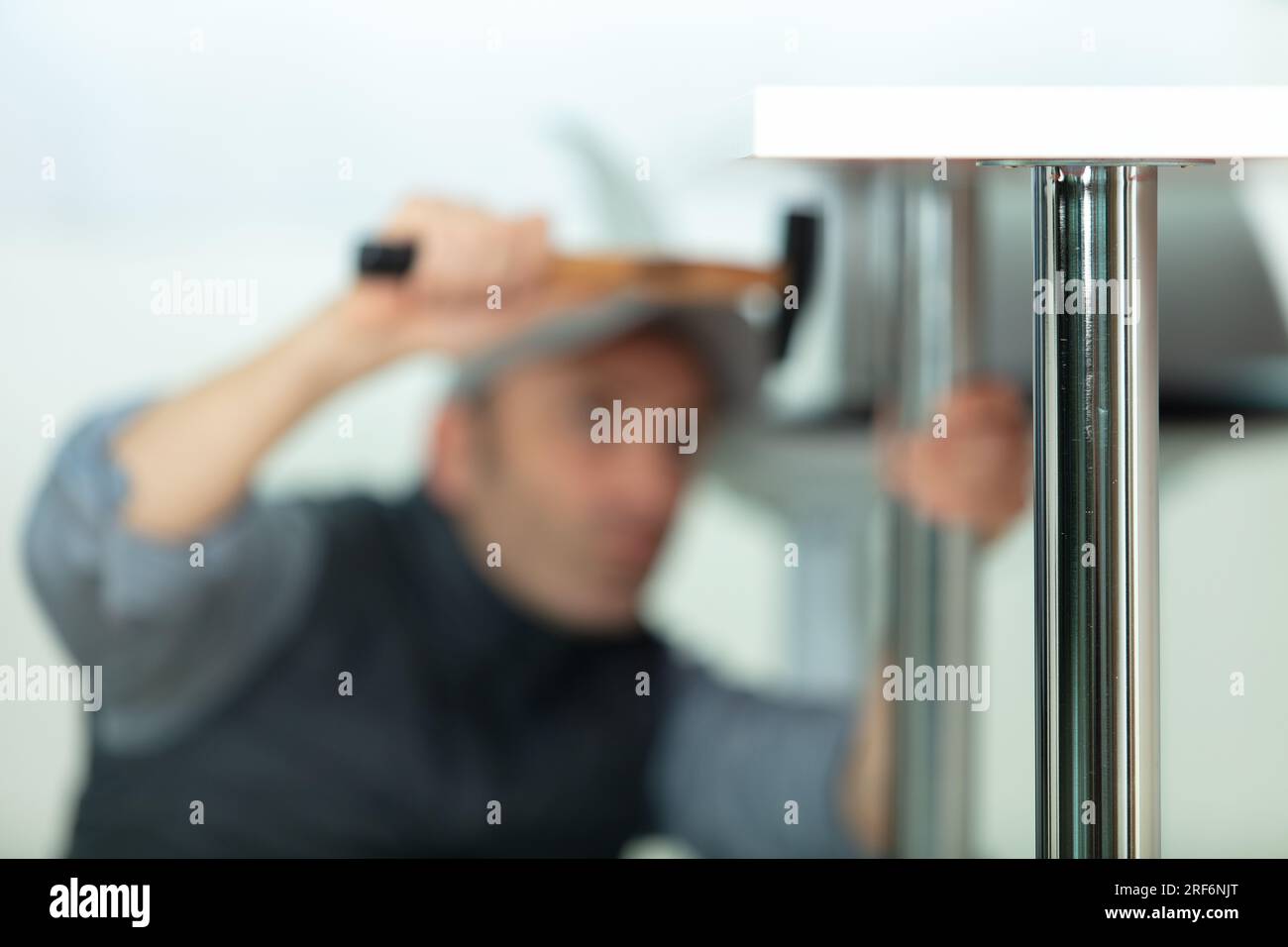 man fixing the leg of the table Stock Photo - Alamy