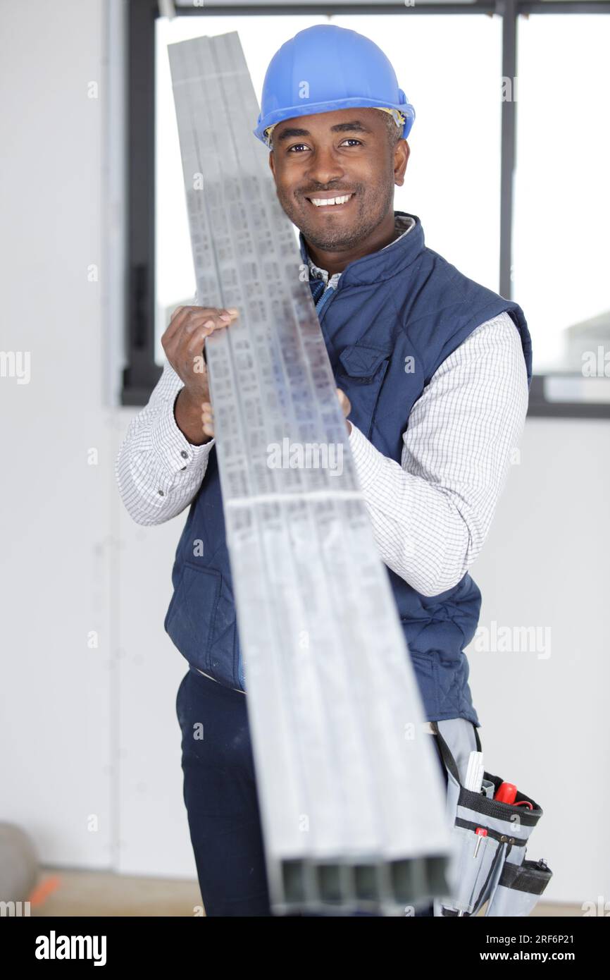blue-collar worker carrying a heavy metallic bar Stock Photo - Alamy