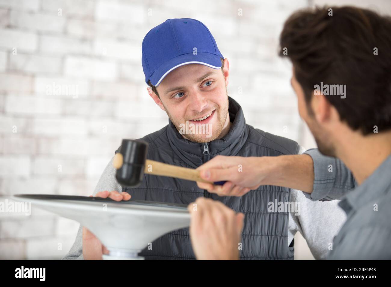 handyman using mallet to locate rubber seal into groove Stock Photo - Alamy