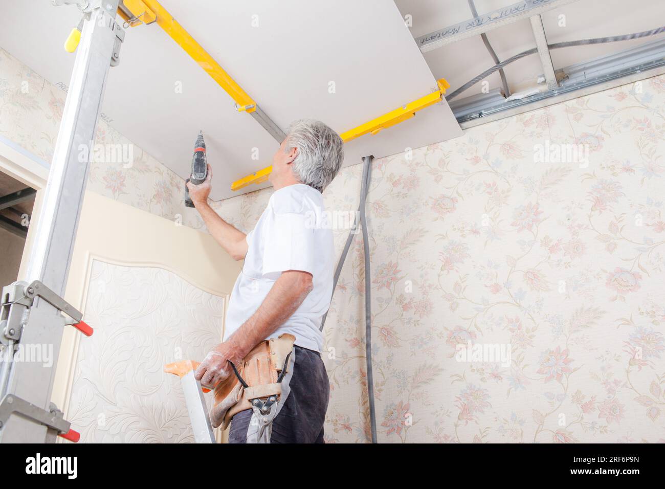 Mason drilling into a ceiling Stock Photo - Alamy