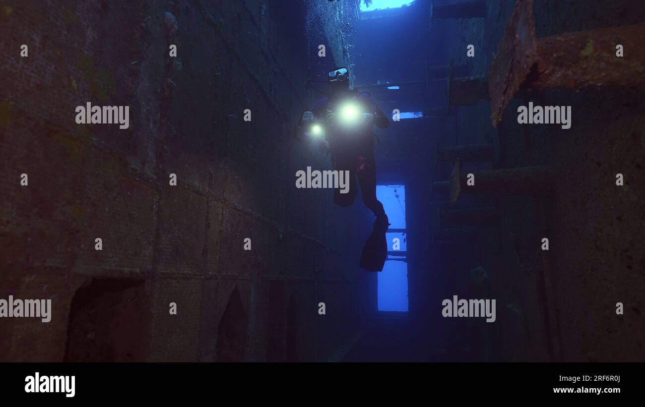 Scuba diver with lantern floats inside of ferry Salem Express shipwreck ...