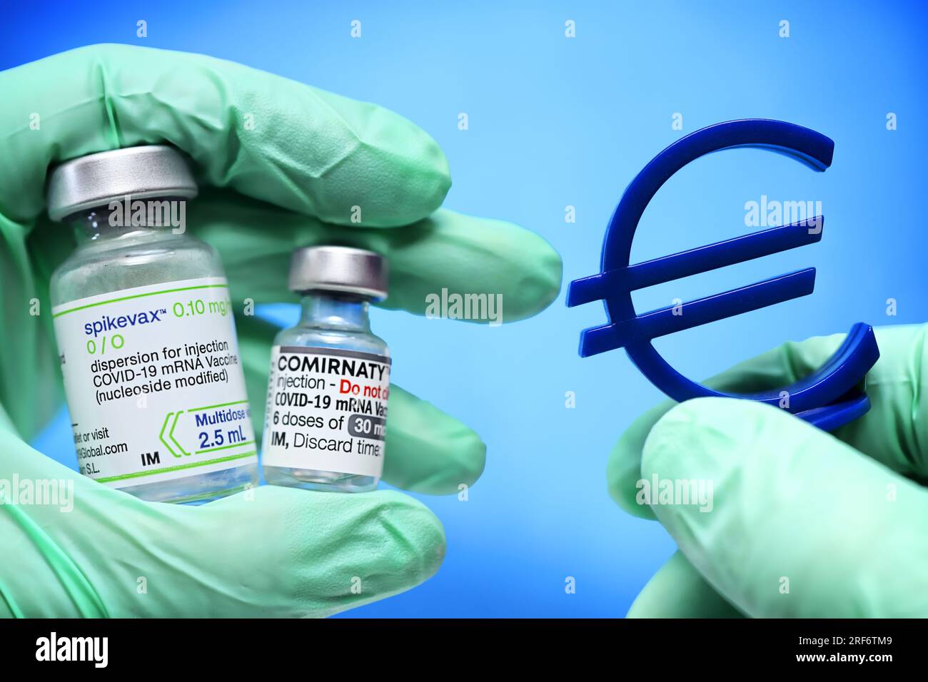 Hand im Latexhandschuh hält Impfstofffläschchen von Moderna und ...