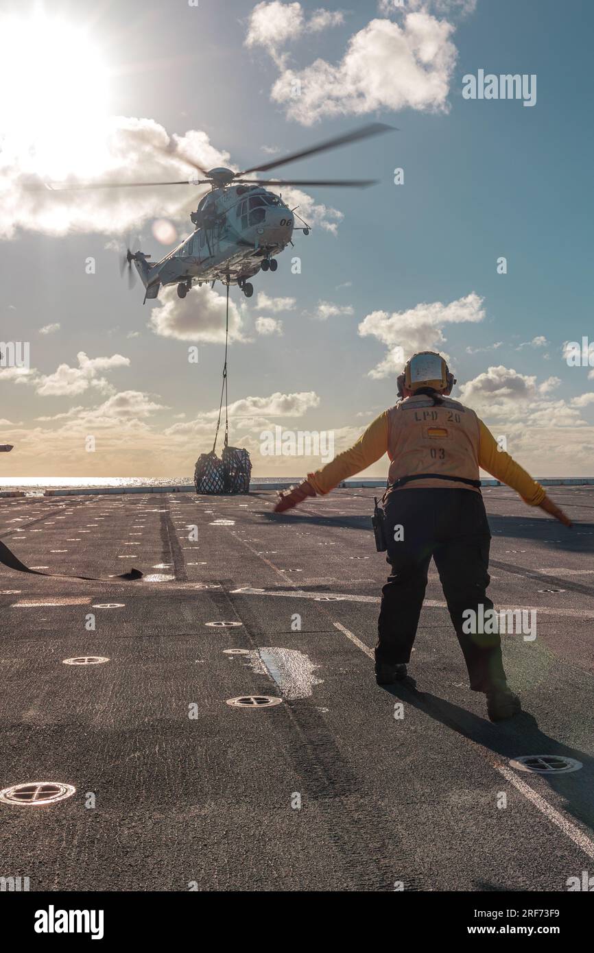 A U.S. Navy sailor guides an EC225 Super Puma helicopter delivering ...