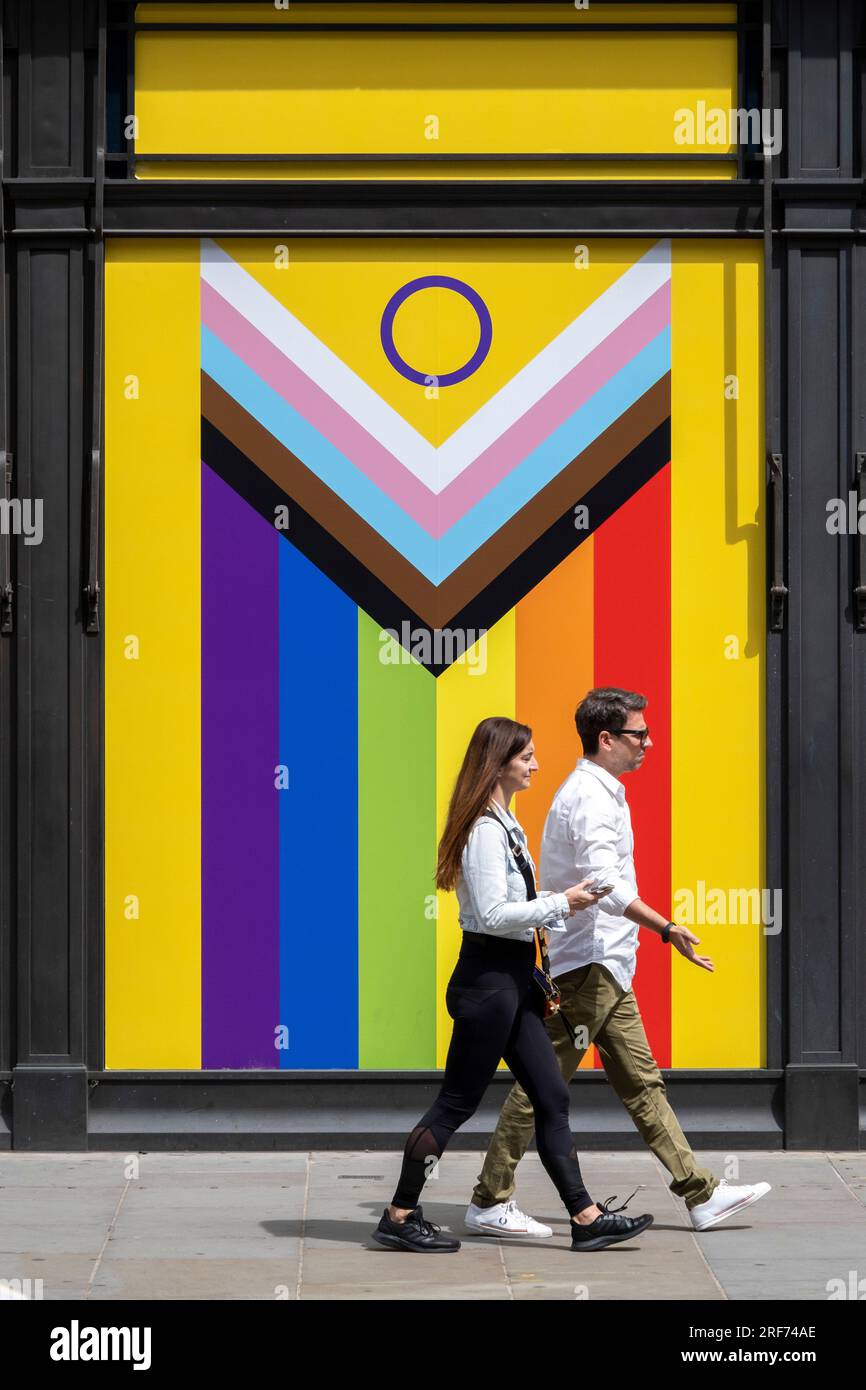 People pass a Pride Progress flag in an empty shop window on 9th July ...