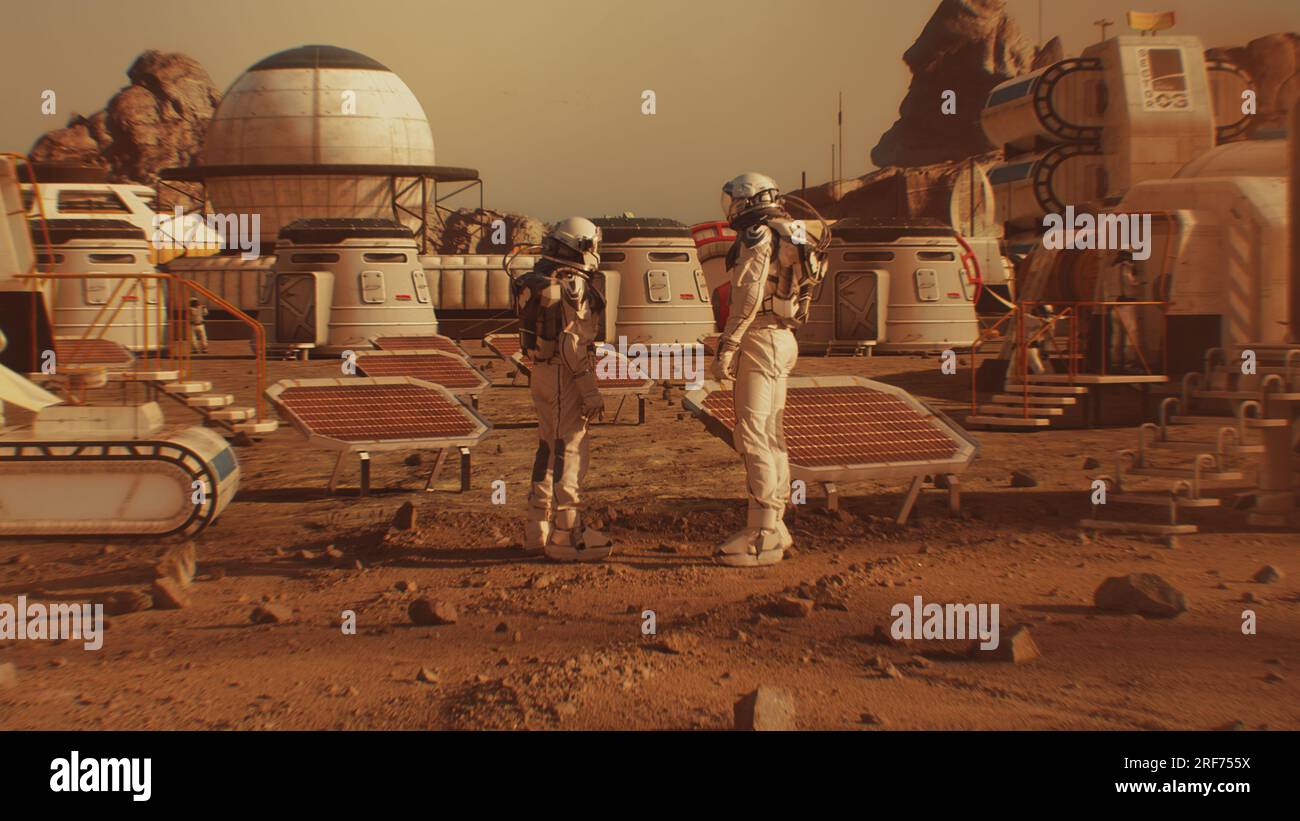 Two astronauts in spacesuits walk toward research station, colony or ...