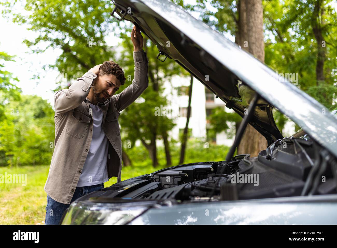 Man checking his broke down car Stock Photo - Alamy