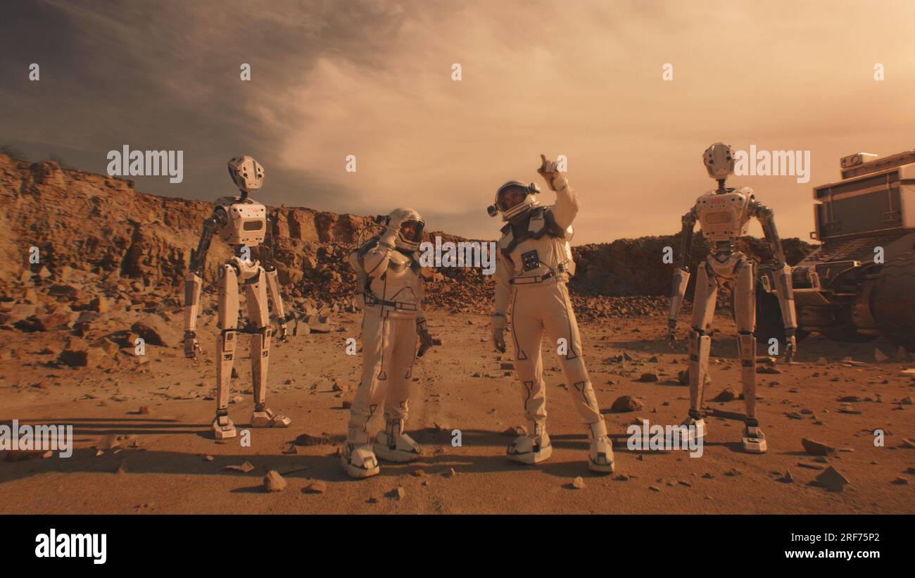 Two astronauts in spacesuits talk, stand on Mars surface with robots. AI powered rover in the ...