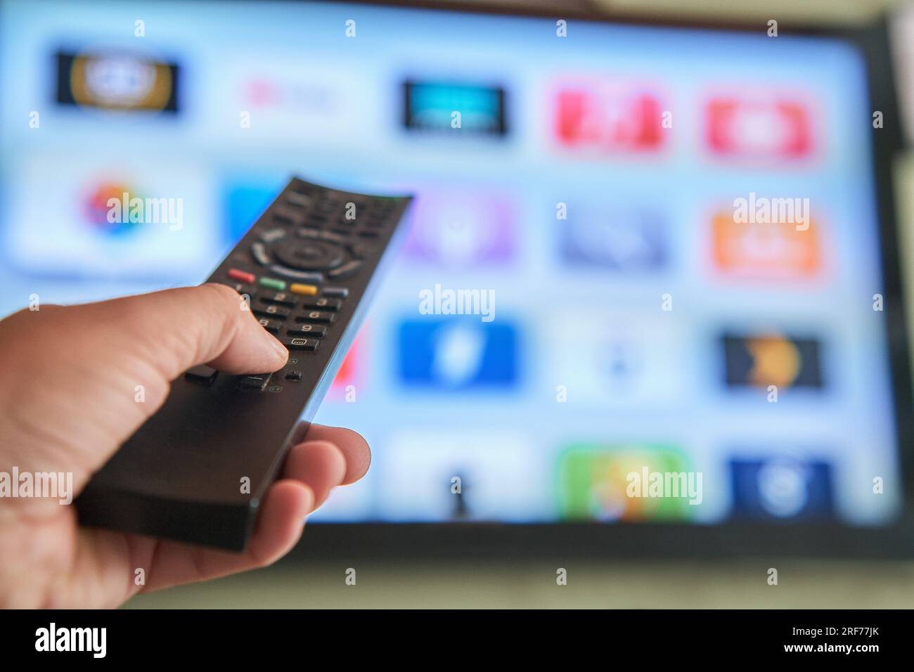 Multimedia streaming concept. Hand holding remote control. TV screen ...