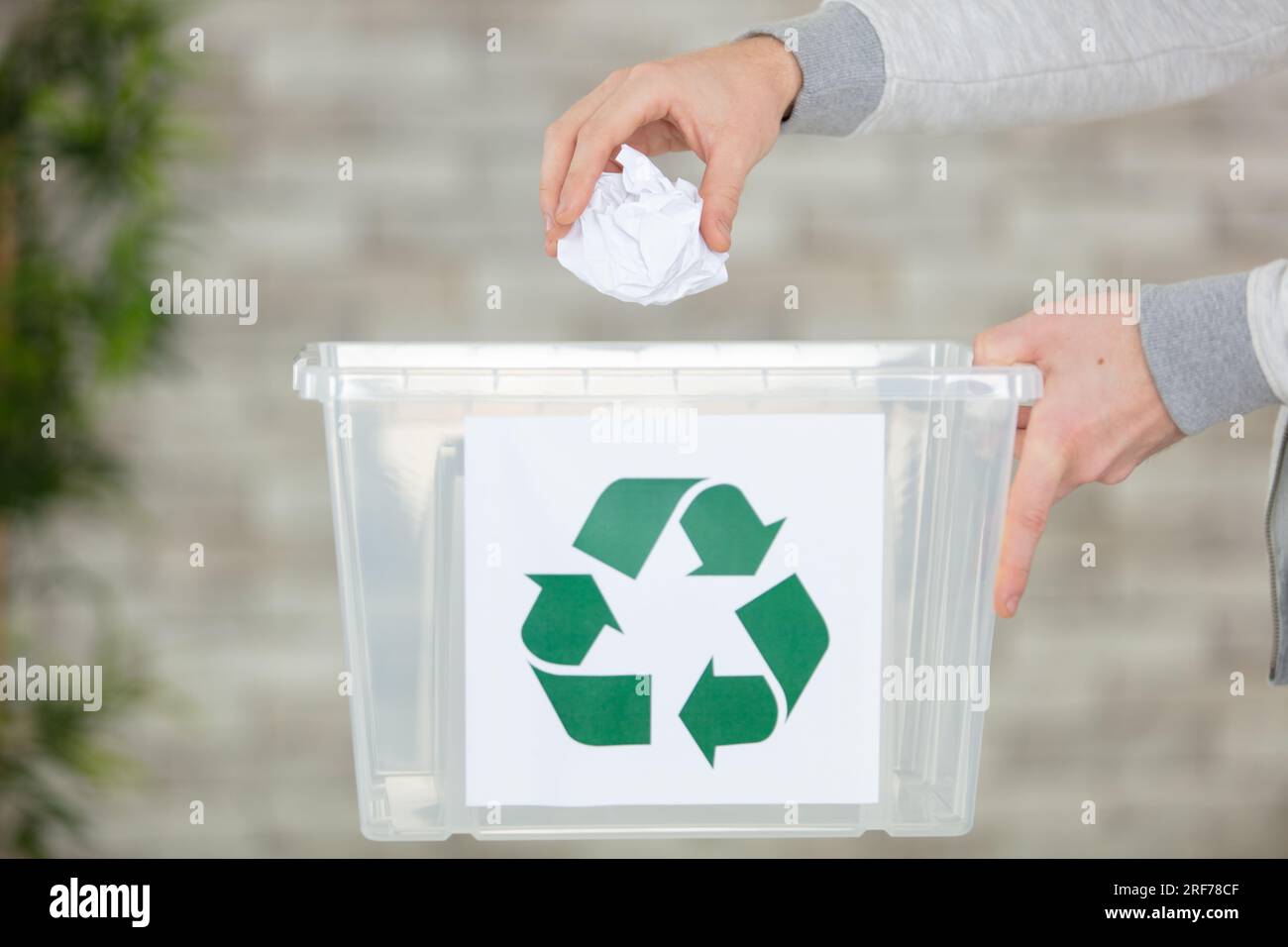 man dropping screwed up paper into recycling bin Stock Photo - Alamy