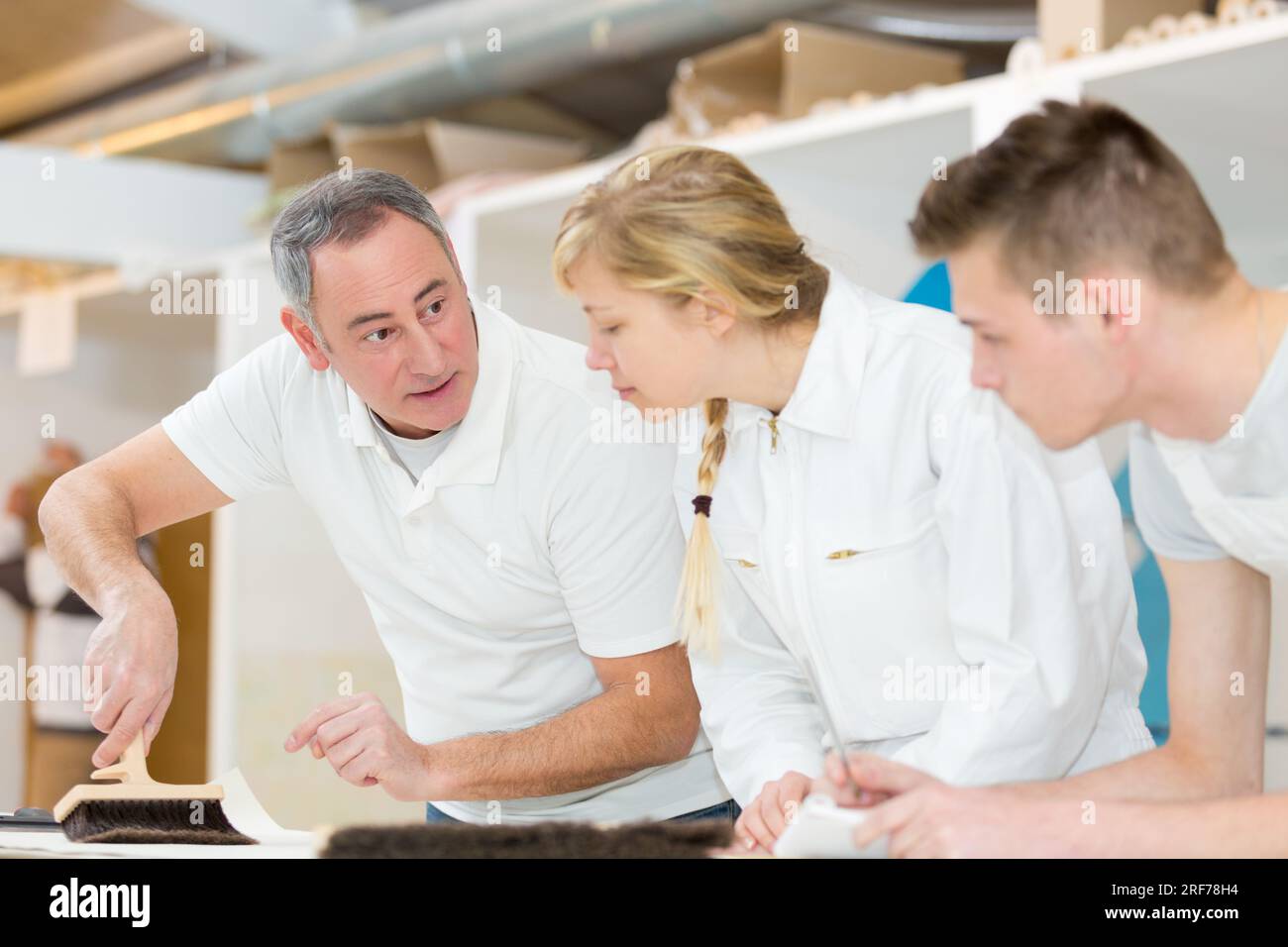 supervisor showing apprentices how to use wallpaper brush Stock Photo ...