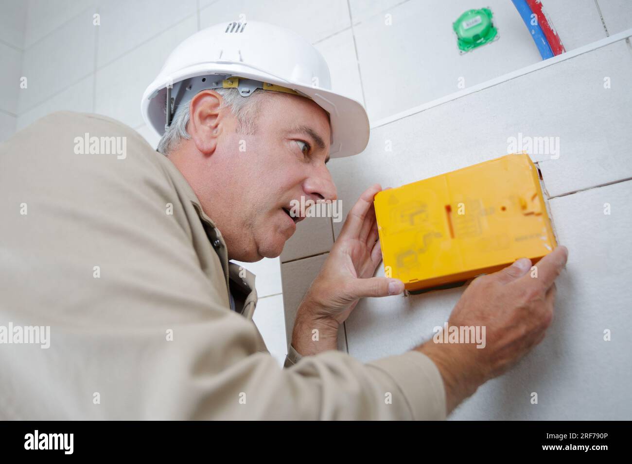 electrician installs wiring box in new apartment Stock Photo - Alamy