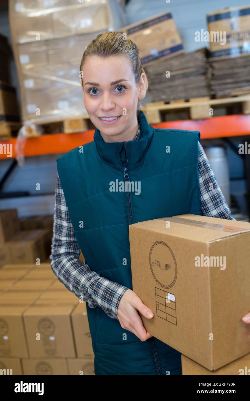 portrait of woman stacking cardboard boxes on pallet Stock Photo - Alamy
