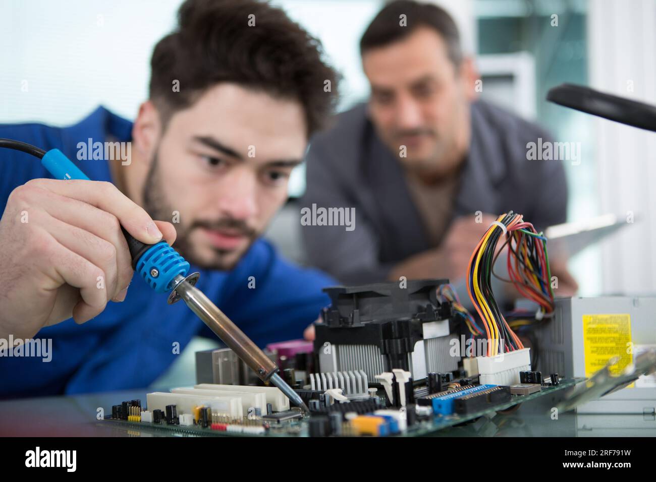 male electronics worker using soldering iron Stock Photo - Alamy
