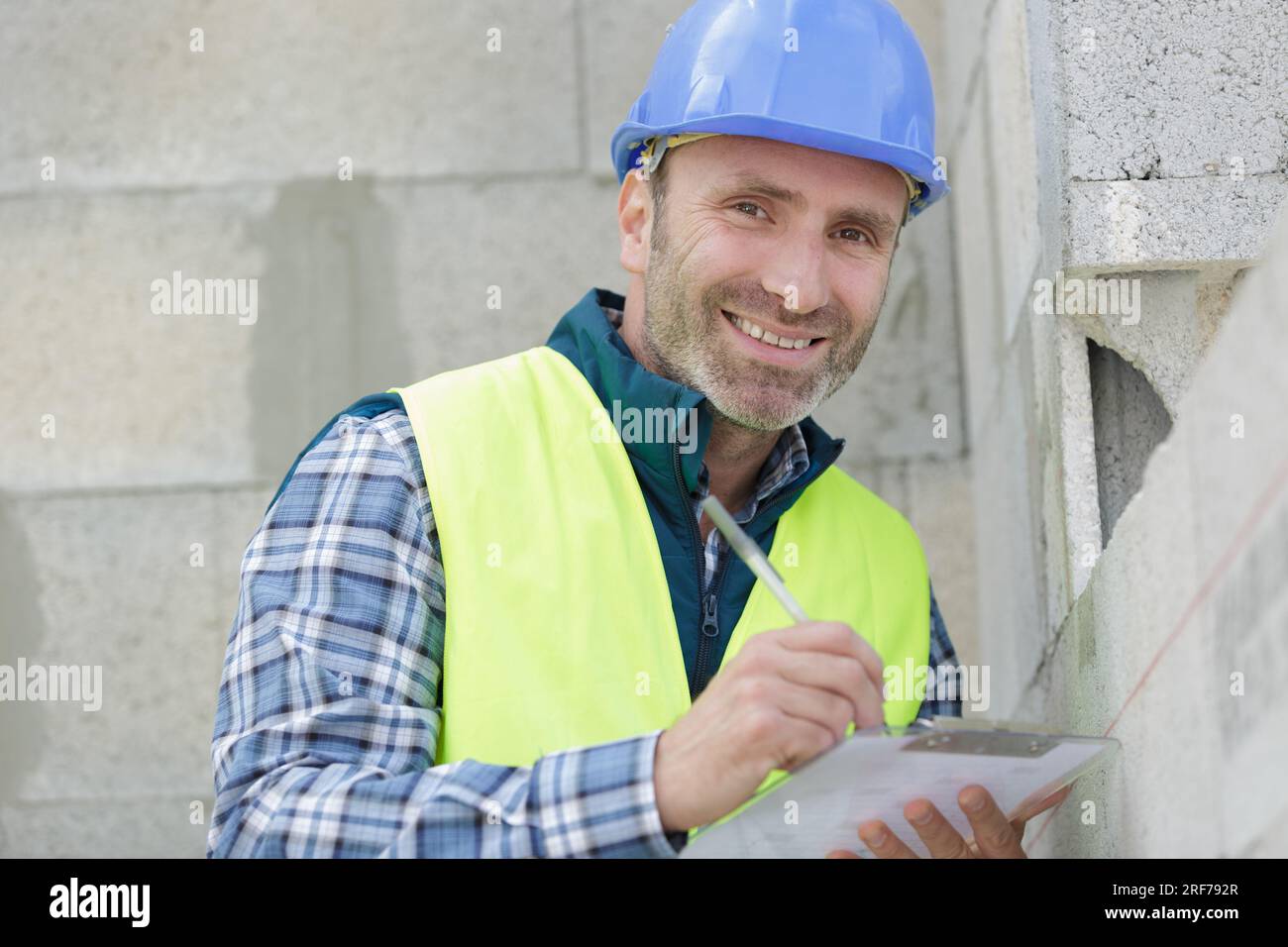 happy builder working with clipboard Stock Photo - Alamy