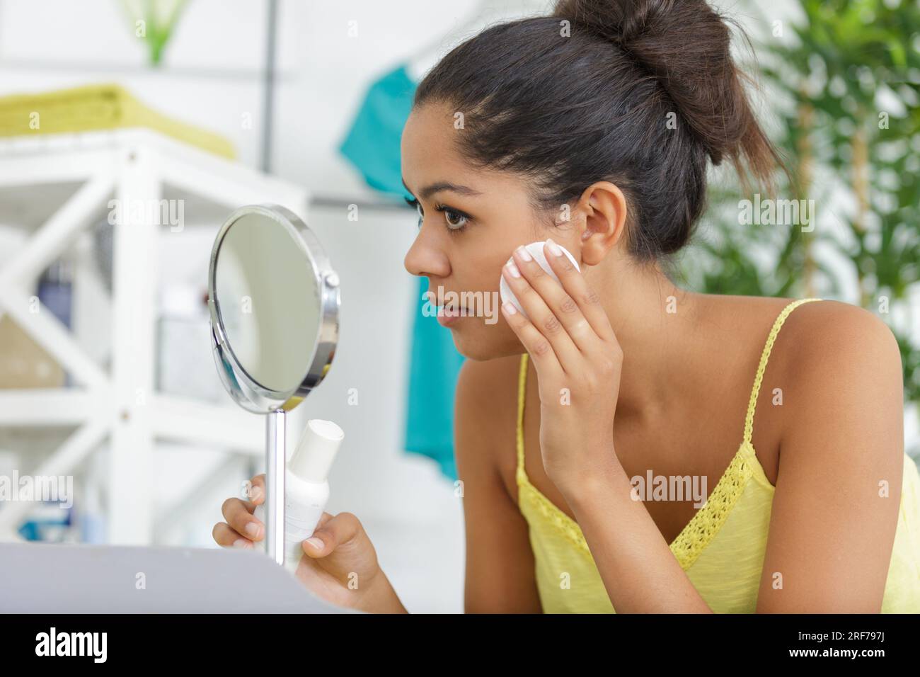 beautiful woman removing makeup in front of mirror Stock Photo - Alamy