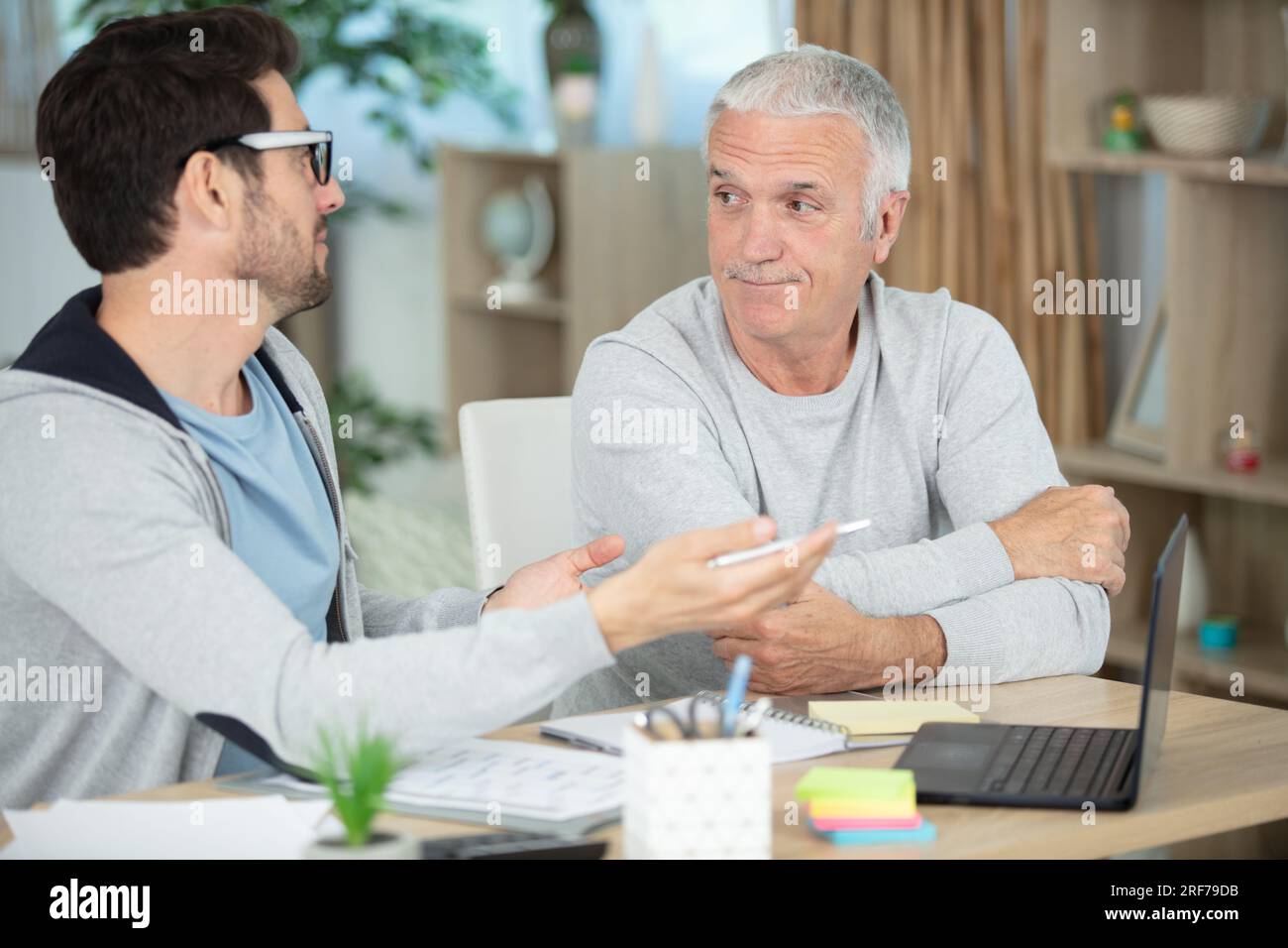 elderly father lends money to his adult son Stock Photo - Alamy